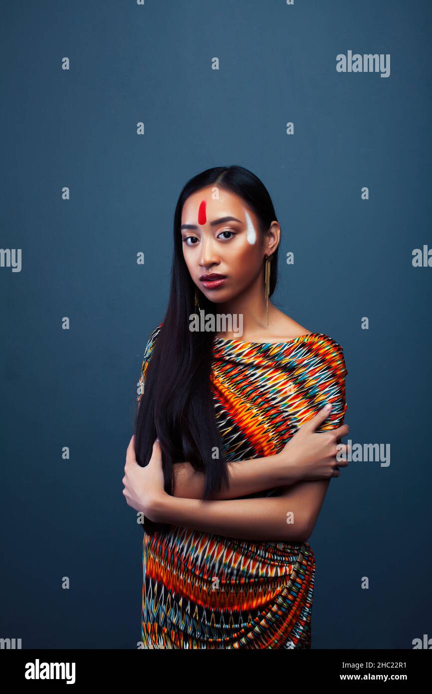 young pretty south asian girl posing in studio on grey background, lifestyle people concept ...