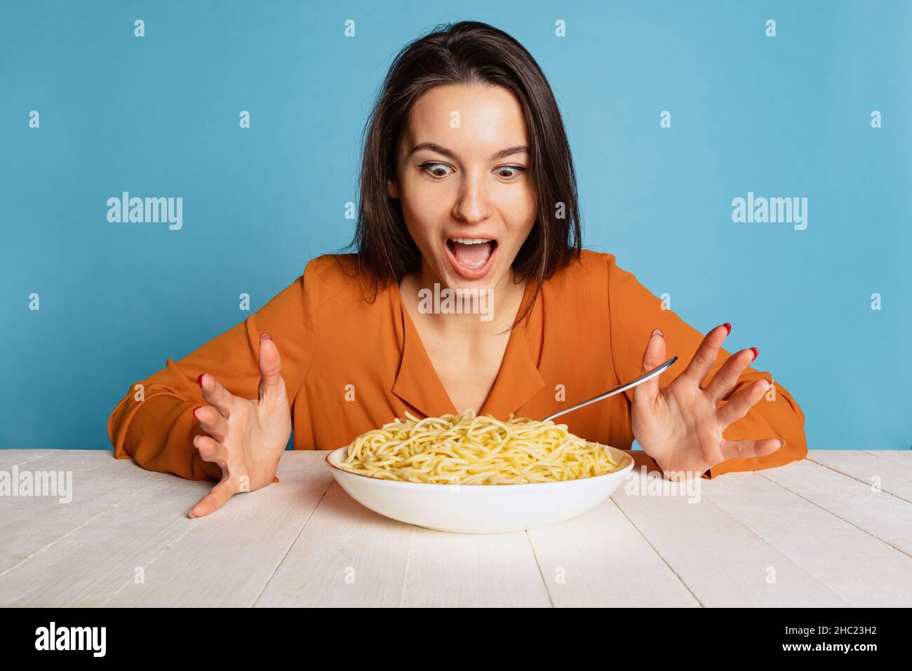 Shocked young girl preparing to eat large portion of noodles isolated ...