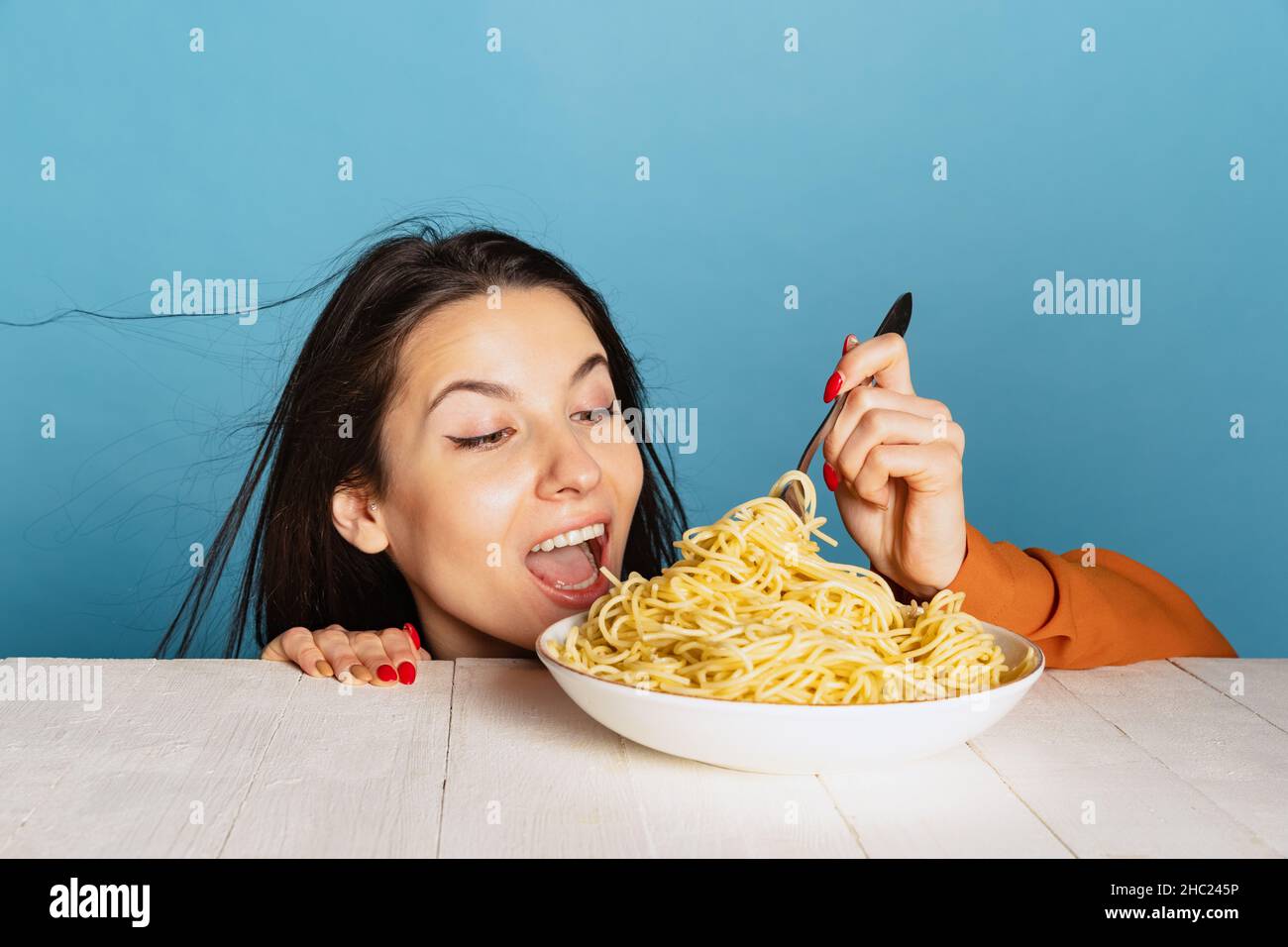 Excited young girl preparing to eat large portion of noodles isolated ...