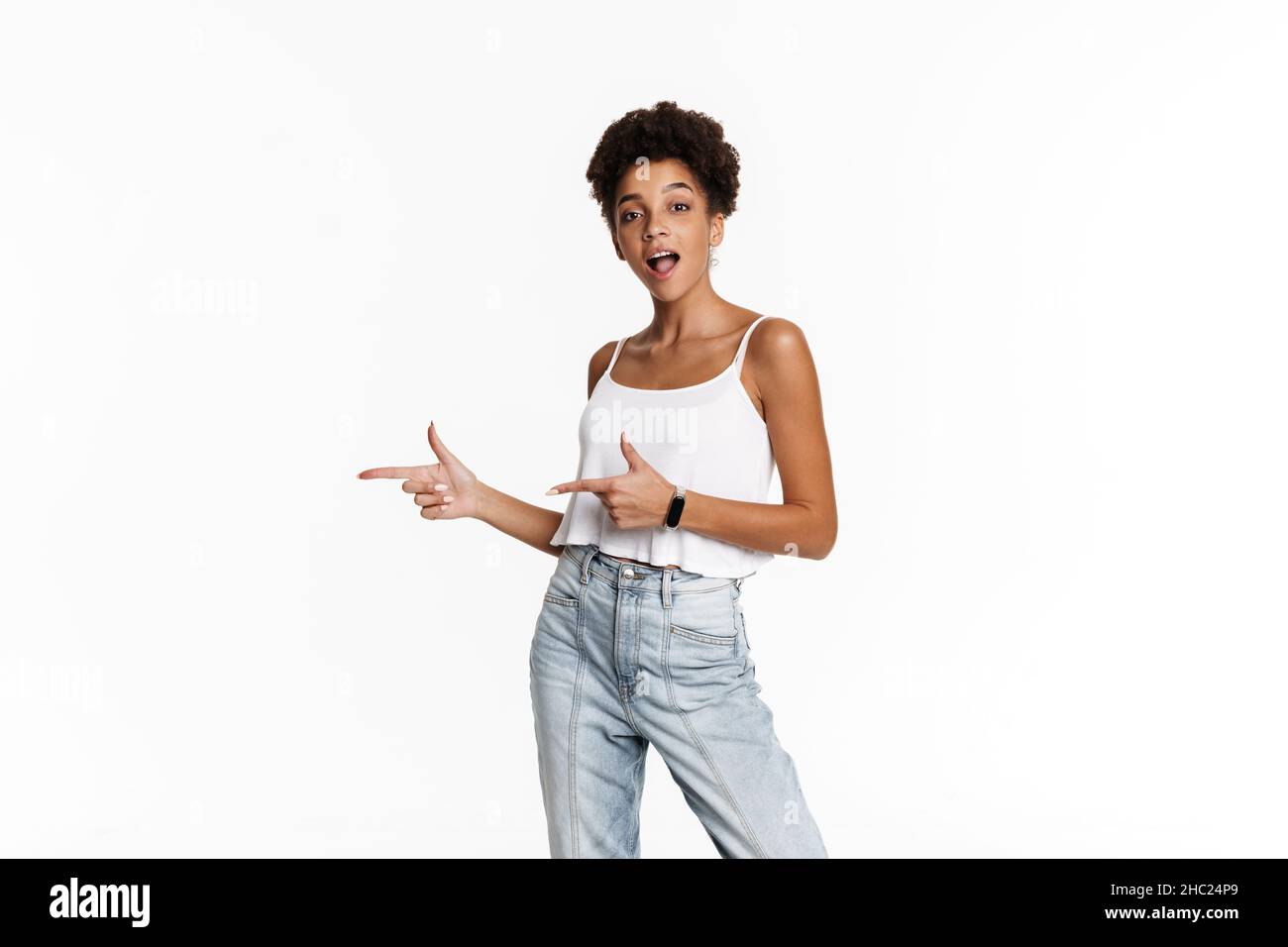 Young black surprised woman in tank top pointing fingers aside isolated ...