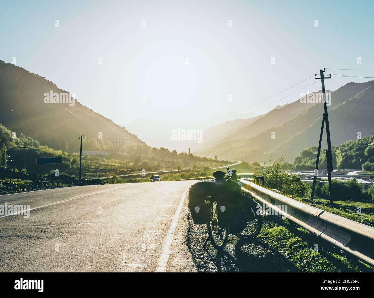 Loaded bicycle with panniers standing on the side of the road with no ...