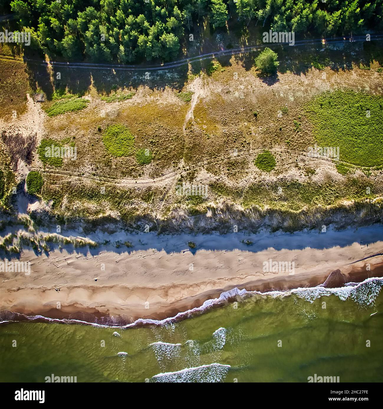 Scenic view down to the shore of curonian spit with green seawater and ...