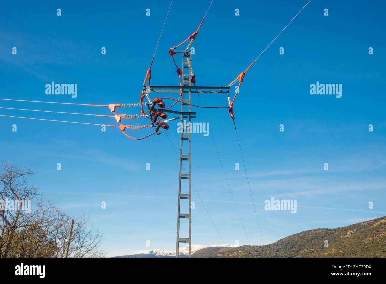 High voltage pylon against blue sky Stock Photo - Alamy
