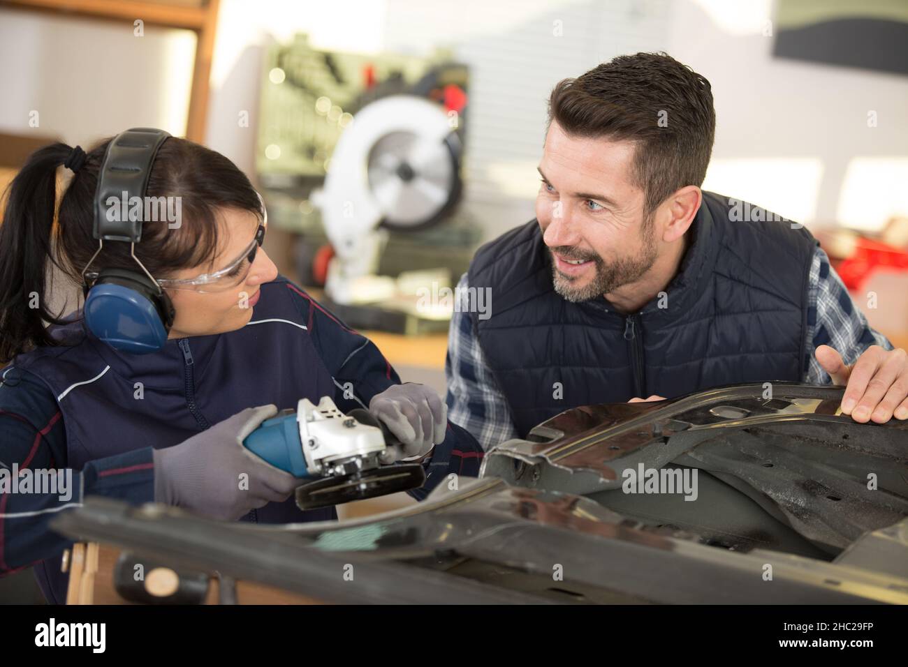 two mechanics - man and woman examining car engine Stock Photo - Alamy