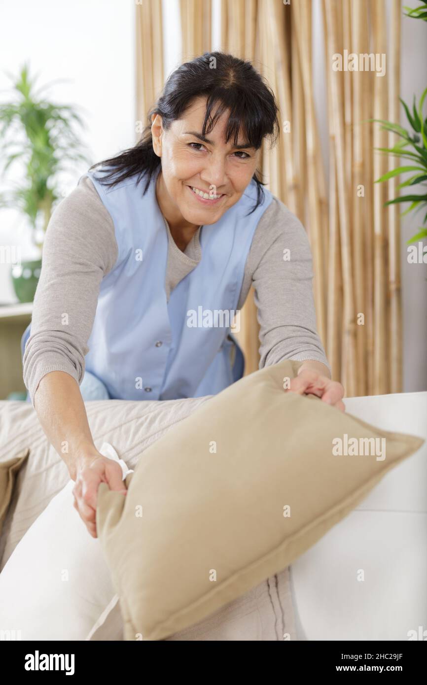 Woman tidying up sofa hi-res stock photography and images - Alamy