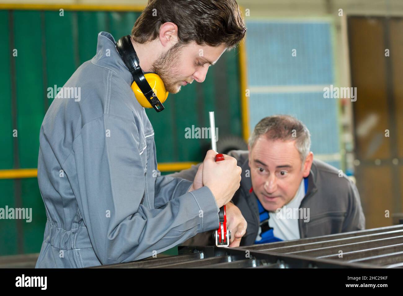 supervisor checking the work of an apprentice engineer in factory Stock ...