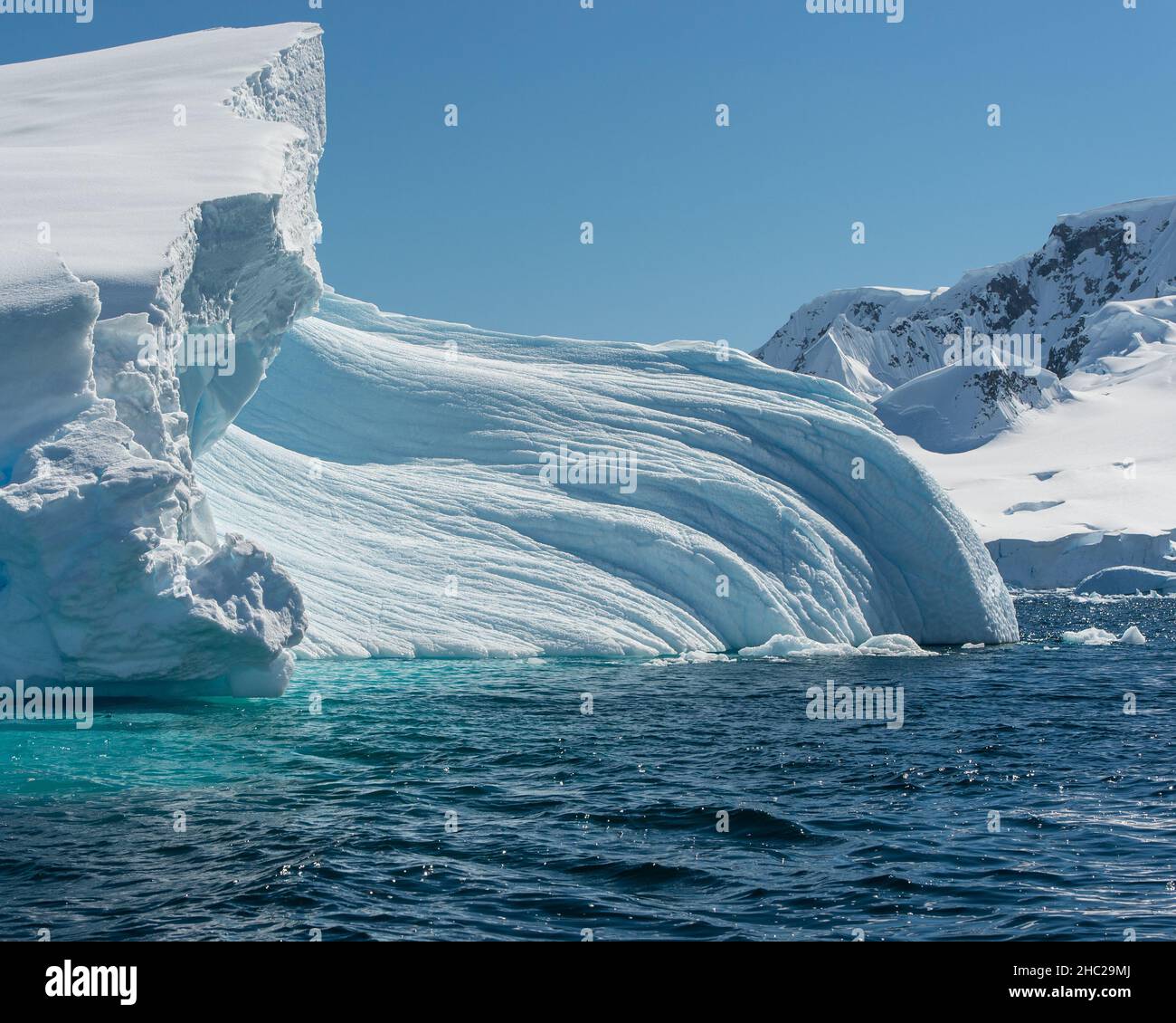 An iceberg with tones of tourquoise showing curves and texture floating ...