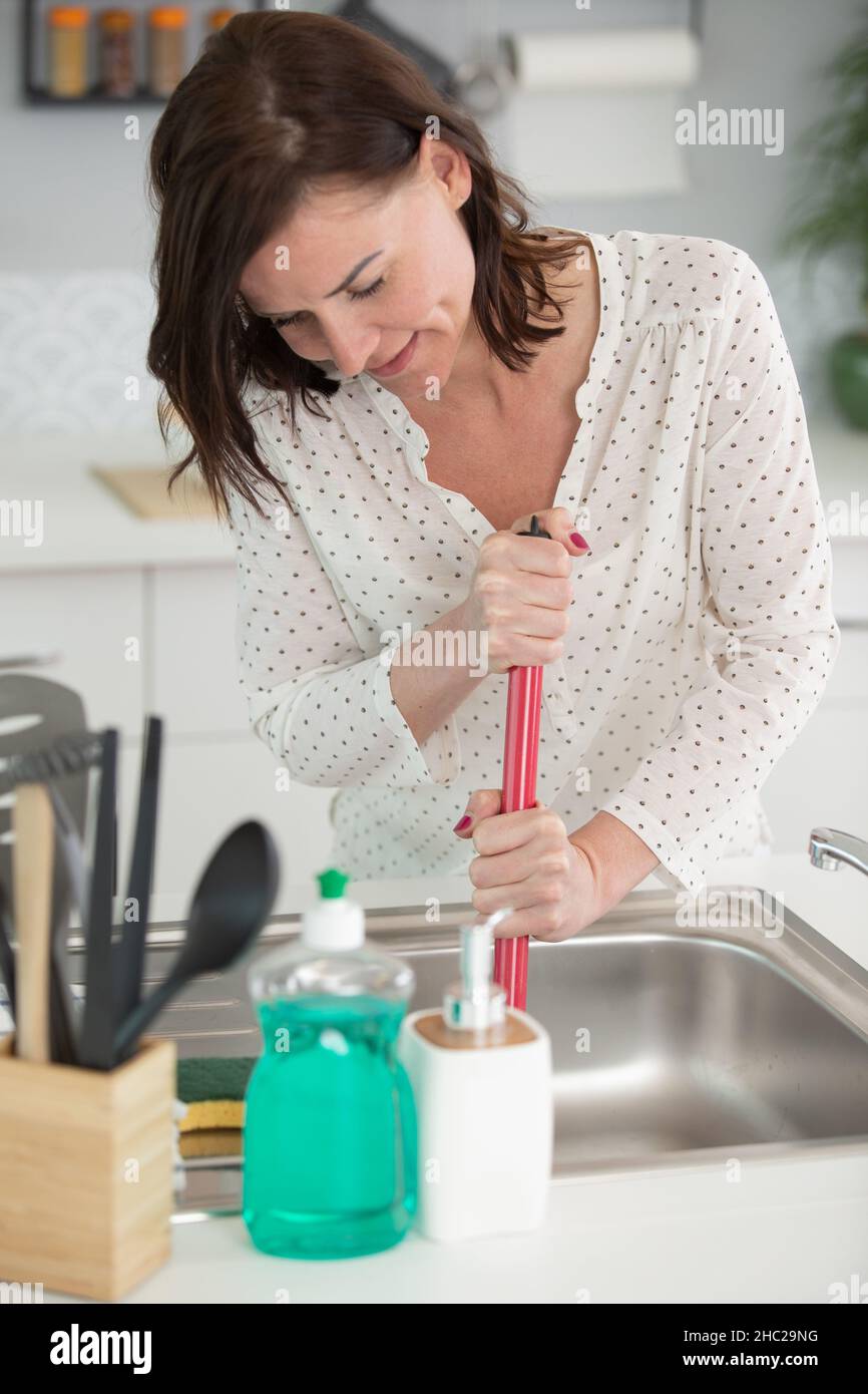 cleaning clogged pipes in the kitchen sink with a plunger Stock Photo ...