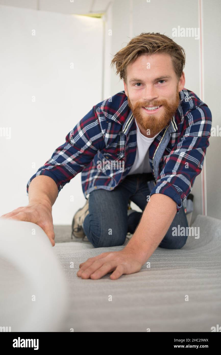 man unrolling underlay on the floor Stock Photo - Alamy