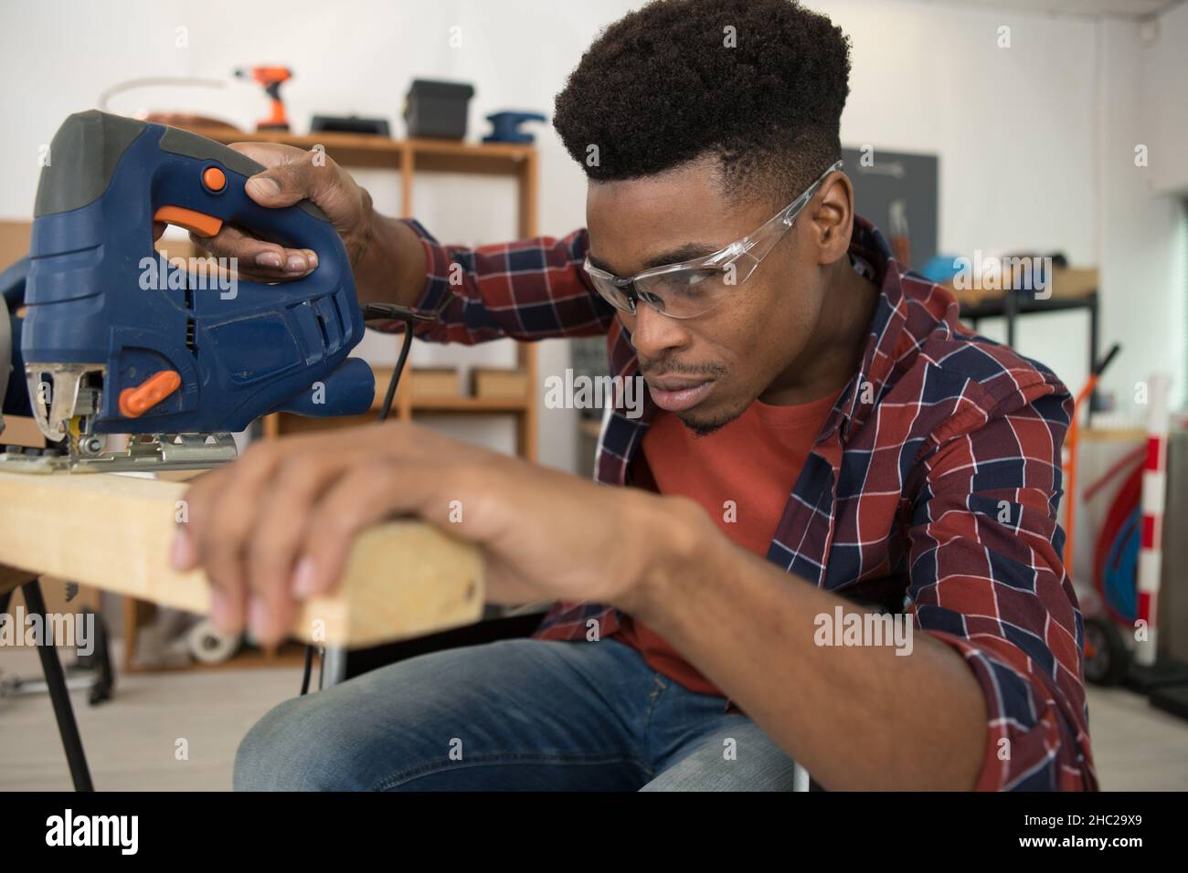 man in wheelchair cutting with jing saw Stock Photo - Alamy