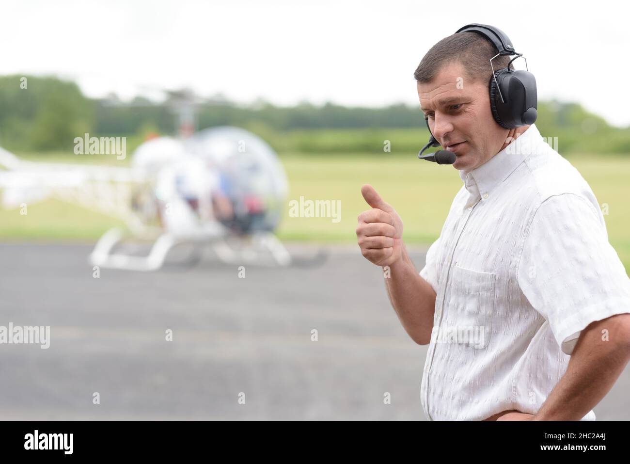 a pilot outside helicopter shows thums up Stock Photo - Alamy