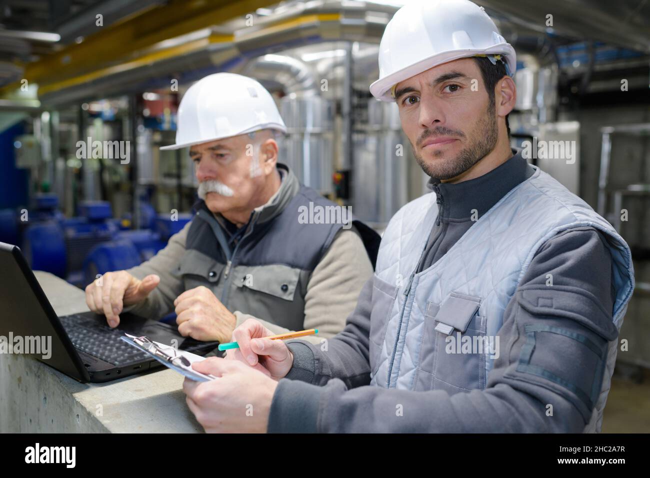 men using laptop in factory Stock Photo - Alamy