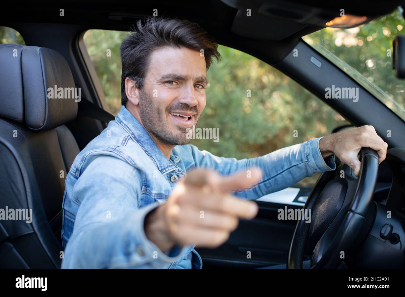 man in car pointing finger to you Stock Photo - Alamy