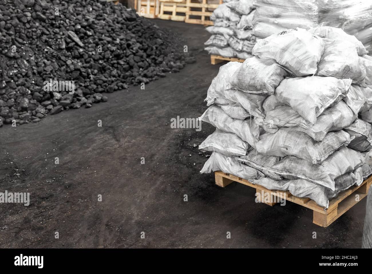 Big heap of dark black lump coal on floor bulk. Charcoal sorage at ...