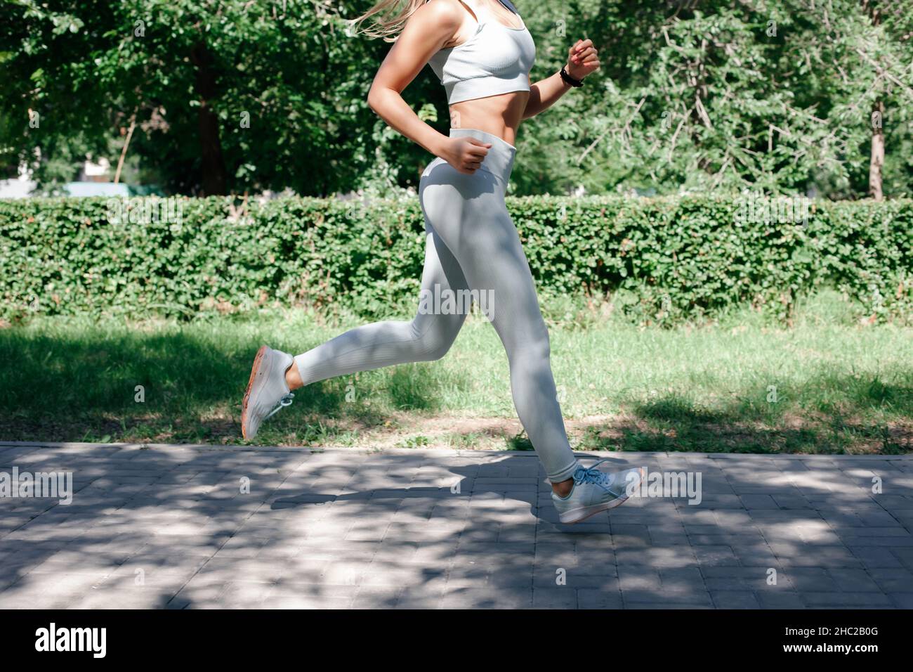 running fast attractive young sporty woman warming up, stretching in ...