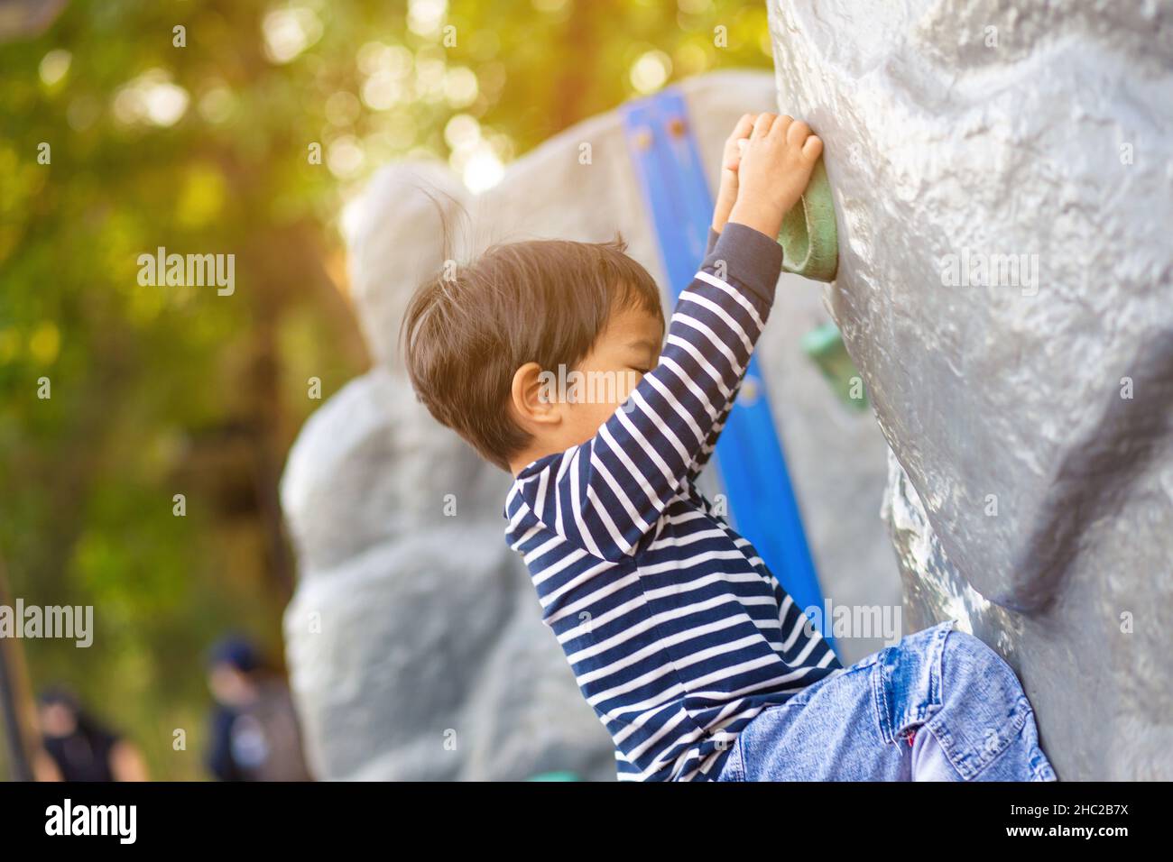 Happy asian 2 year boy climbing and playing at the children playground ...