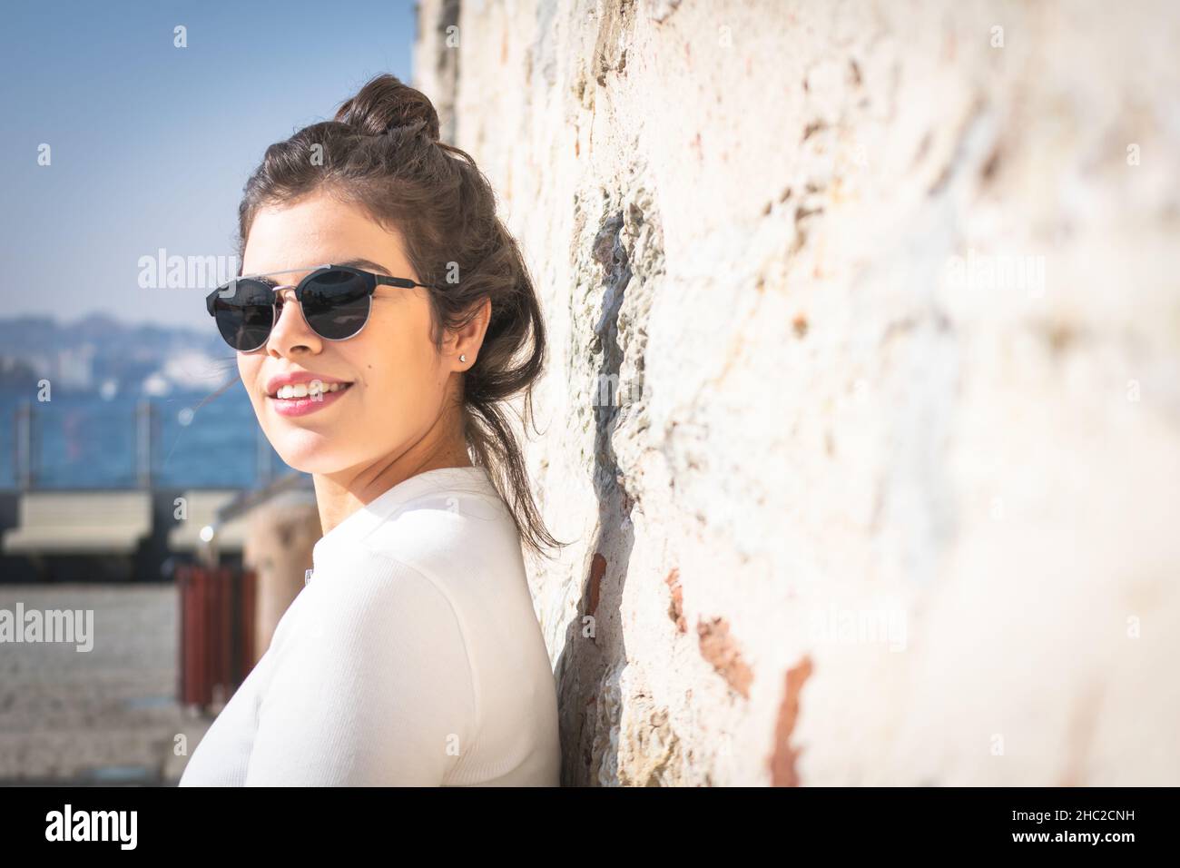 Attractive brunette girl in casual clothes is leaning to colorful rocky ...