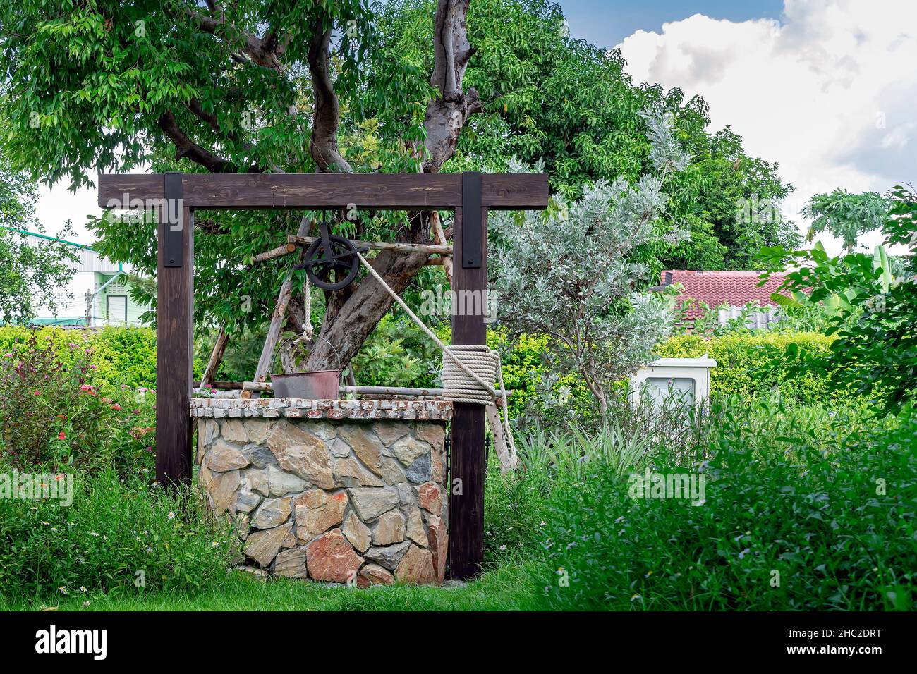 Beautiful artesian well made by stones and wheel pulley with metal ...