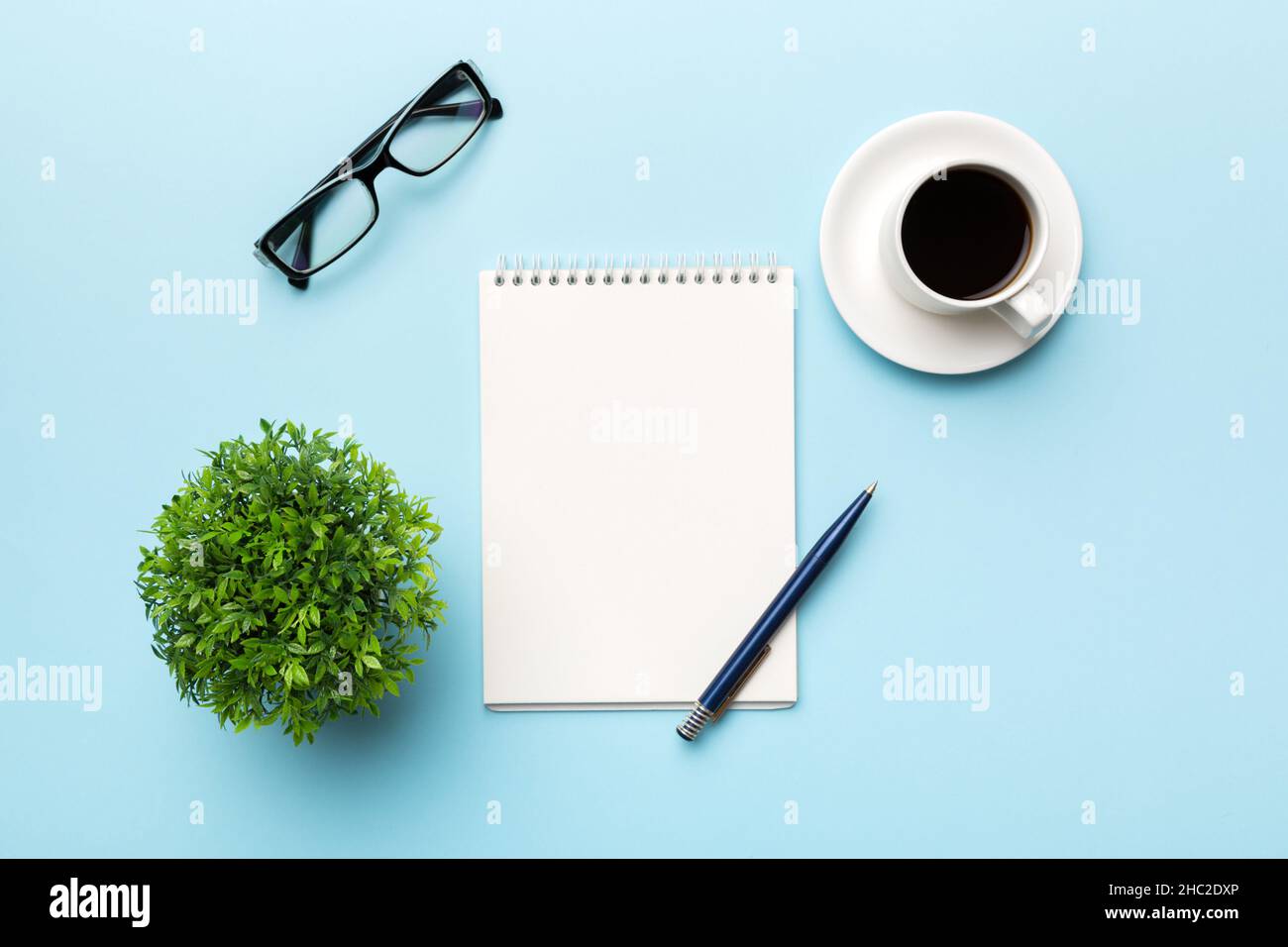 Modern office desk table with notebook and other supplies with cup of ...