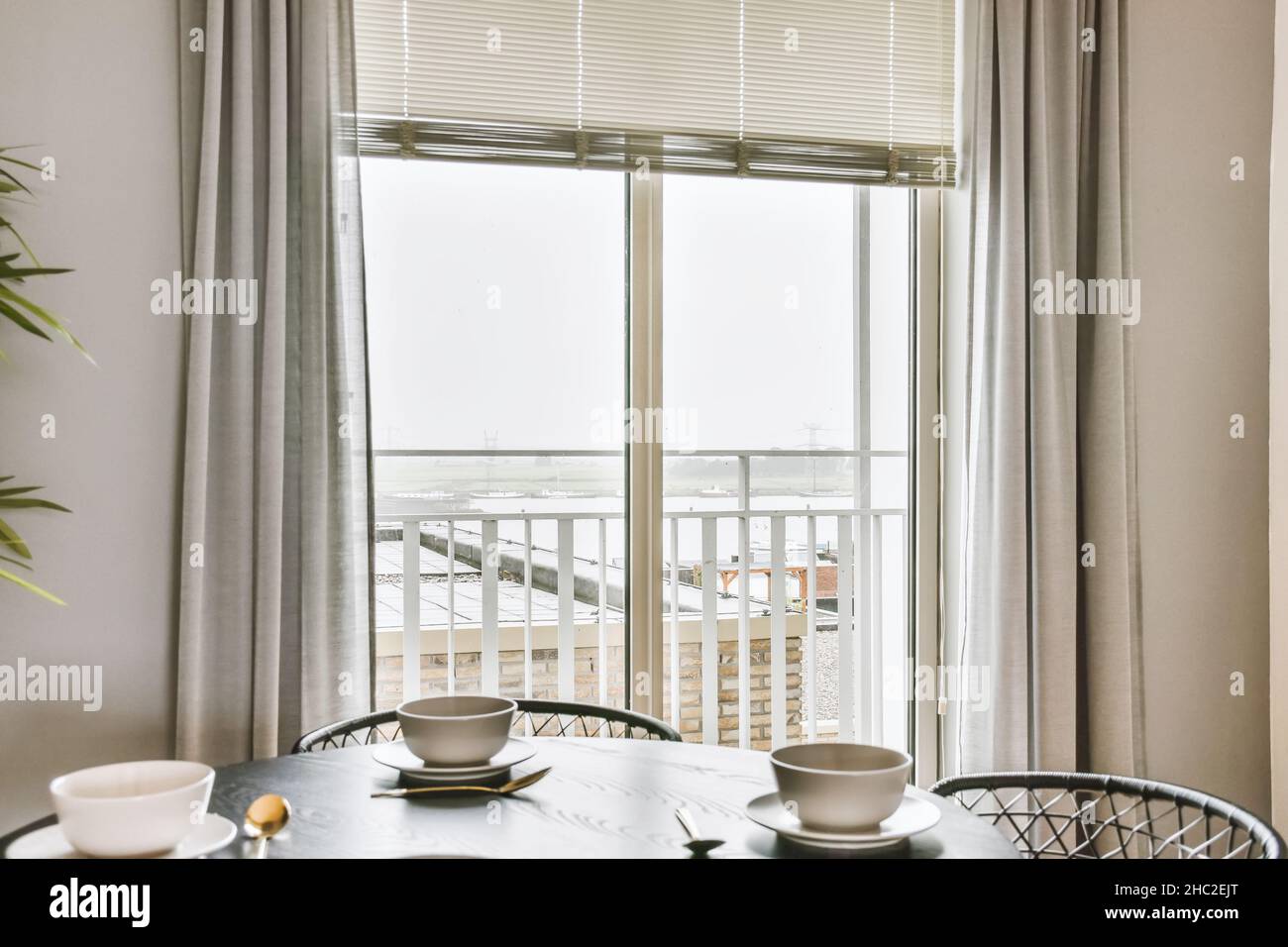 Small cozy dining area with a black table with cups and chairs Stock ...