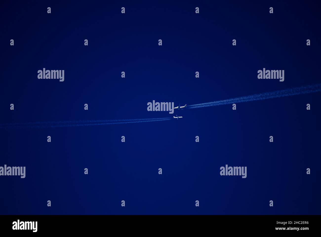 Jet streams of two airplanes flying near by - towards each other on a ...