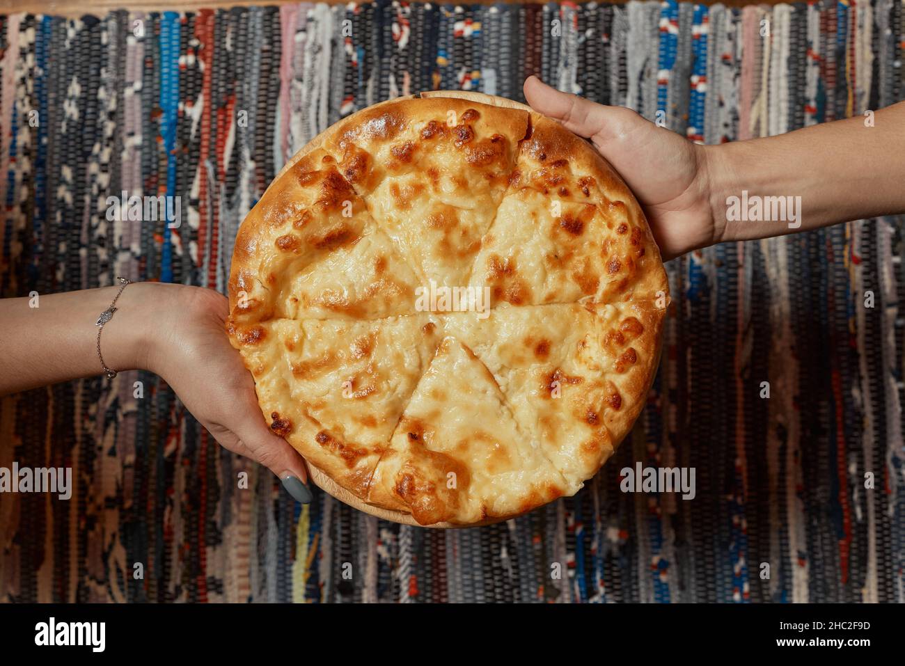 Khachapuri on the table. Top view female hand Stock Photo - Alamy