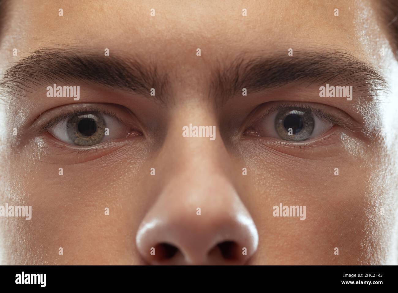 Blue eyes. Close-up upper face of young man. Man looking at camera ...