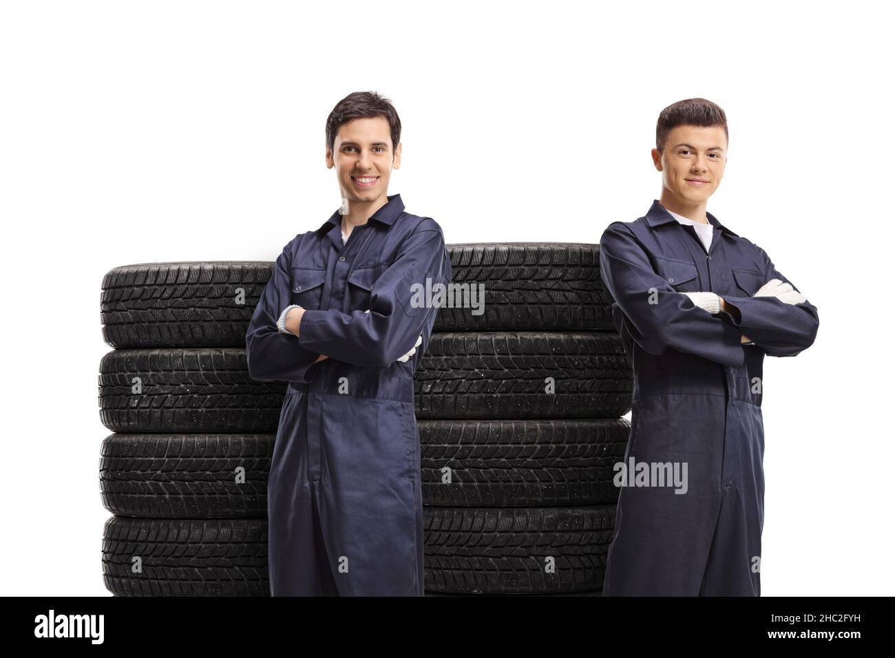 Auto mechanic workers posing with piles of tires isolated on white ...