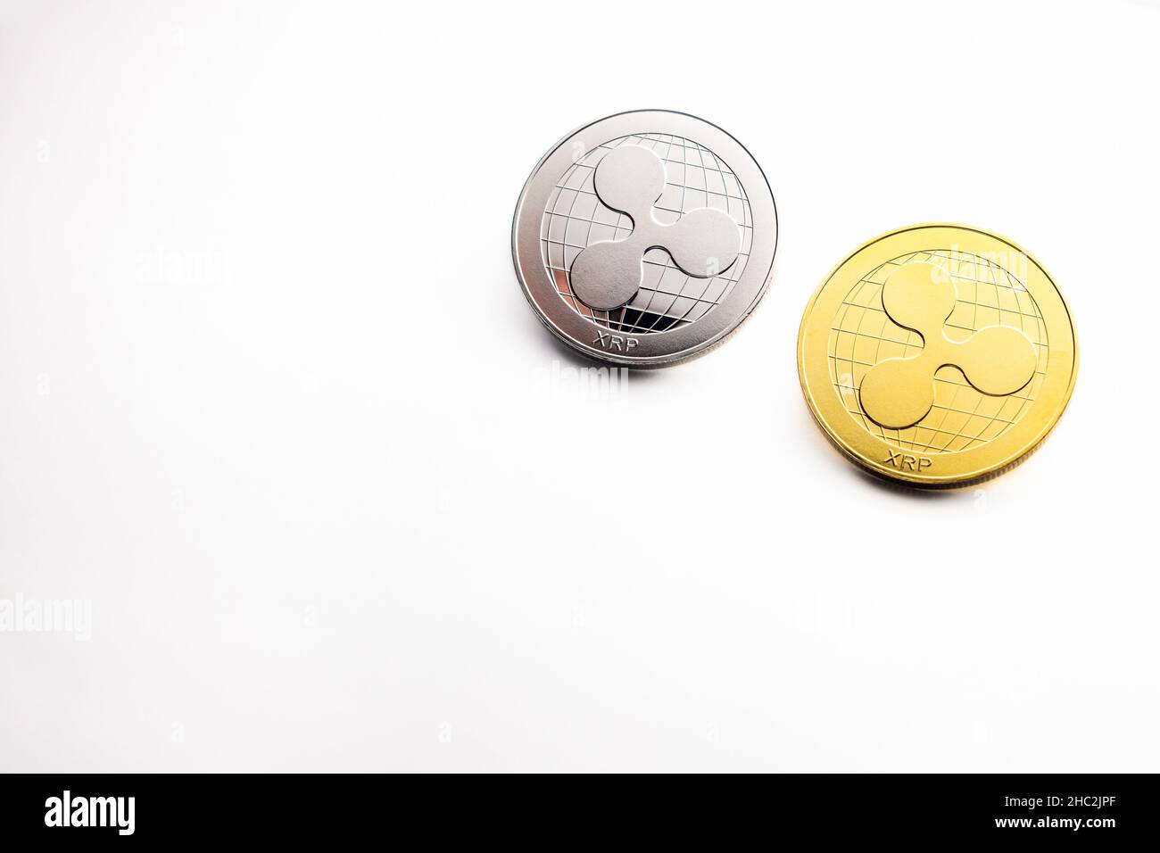 Multiple XRP-Ripple silver and gold coins photographed on a white ...
