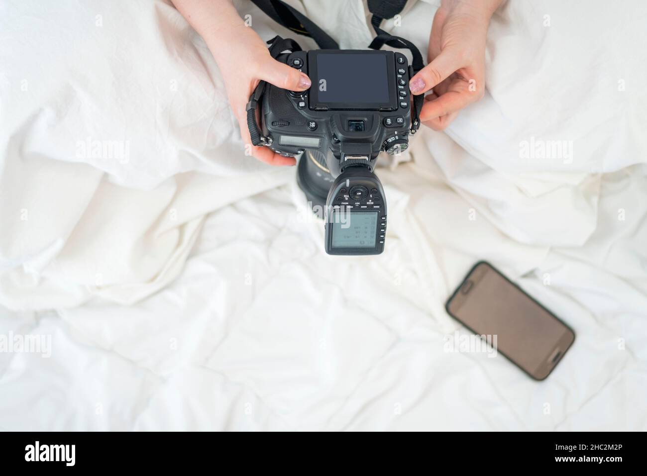 Female photographer holds camera with flash. Top view. SLR camera ...