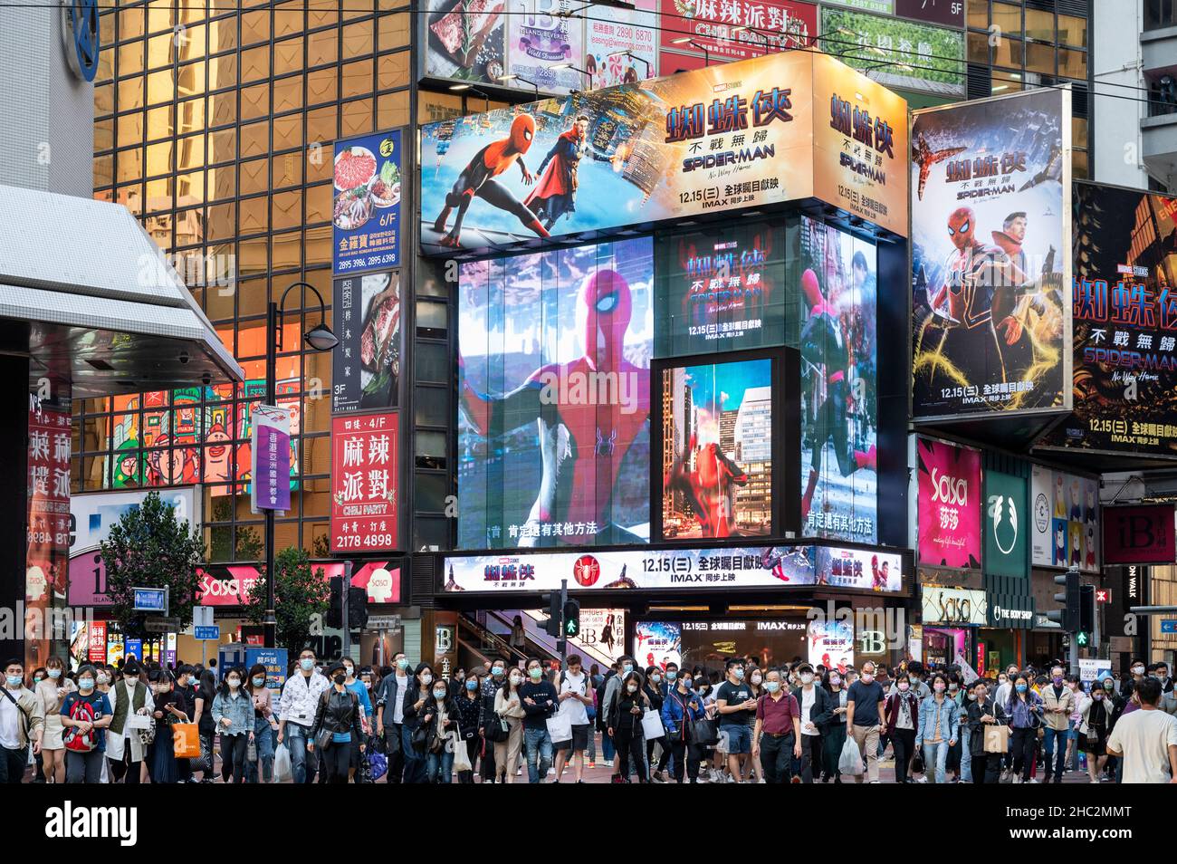 People are seen crossing the street as advertisement billboard screens ...