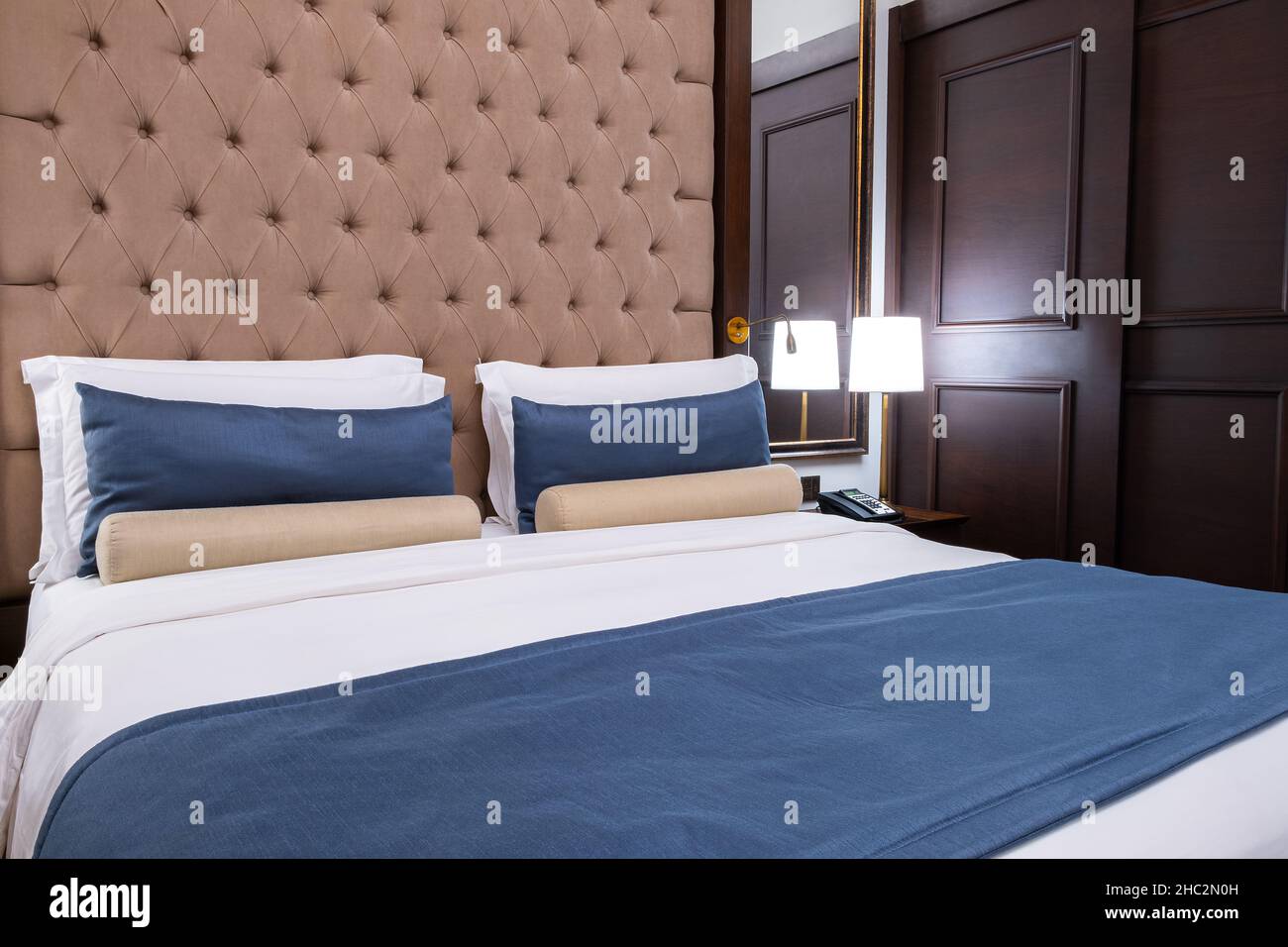 Big comfortable bed in hotel room Stock Photo - Alamy