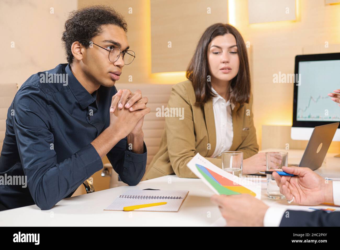 Going over details. Group of young confident business people discussing ...