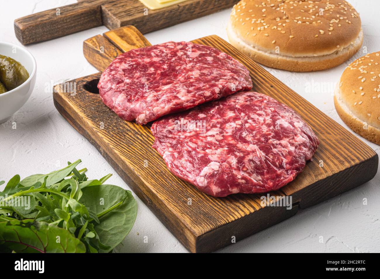 Raw minced meat cutlets with herbs and spices set, on white stone ...