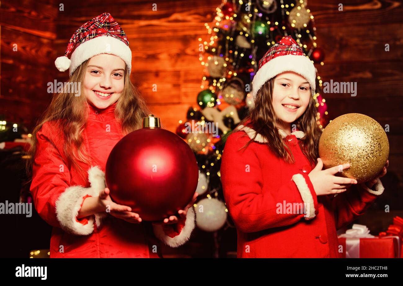 Decorate christmas tree together. Girls sisters santa claus costumes ...