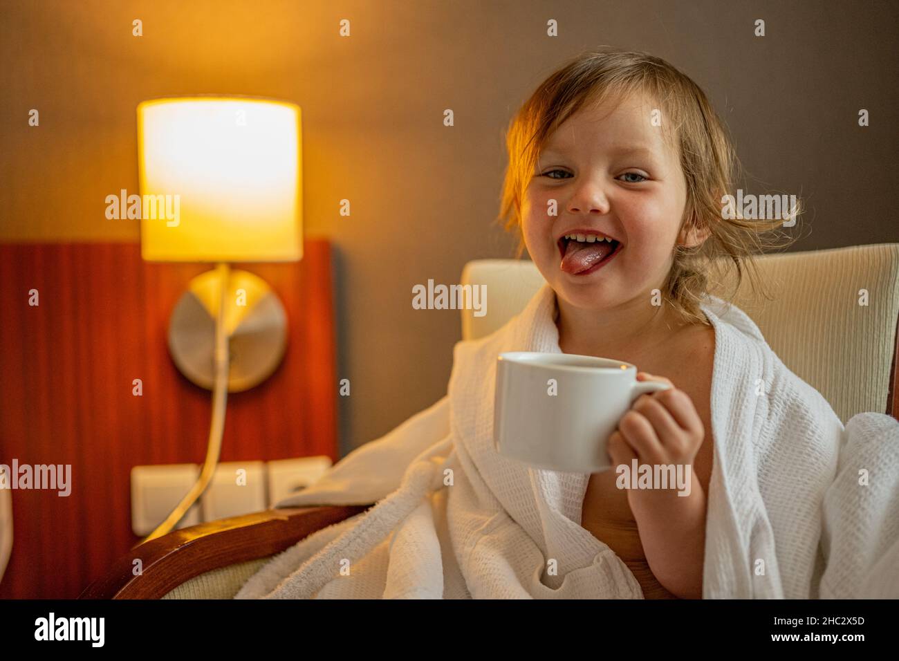 Portrait of a cute little girl drinking tea in a bedroom Stock Photo ...