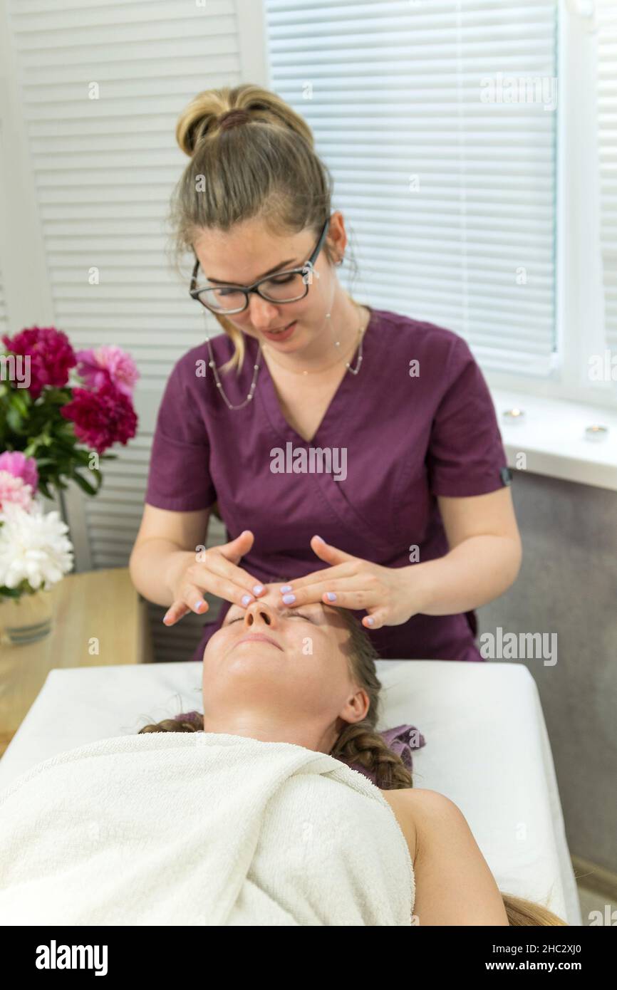 Young woman in beauty salon. Relaxing facial massage for beauty and ...