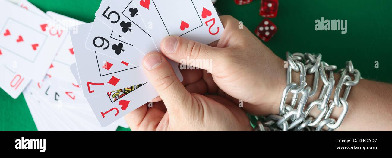 Men hands are tied with chain and hold playing cards closeup Stock ...