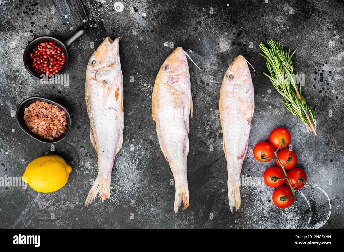Raw Goatfish fresh whole fish set, with ingredients and herbs, on black ...