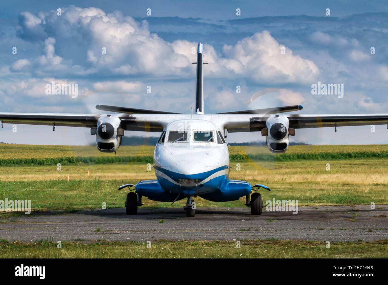 Front view of taxiing a turboprop passenger airplane at a rural ...