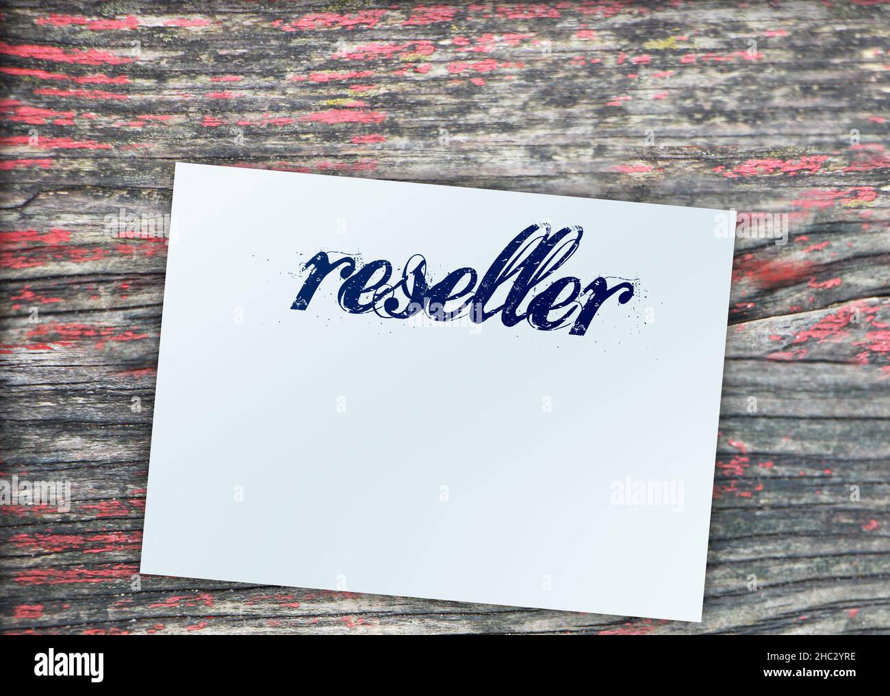 RESELLER Word on page and paper dollar signs around on wooden table ...