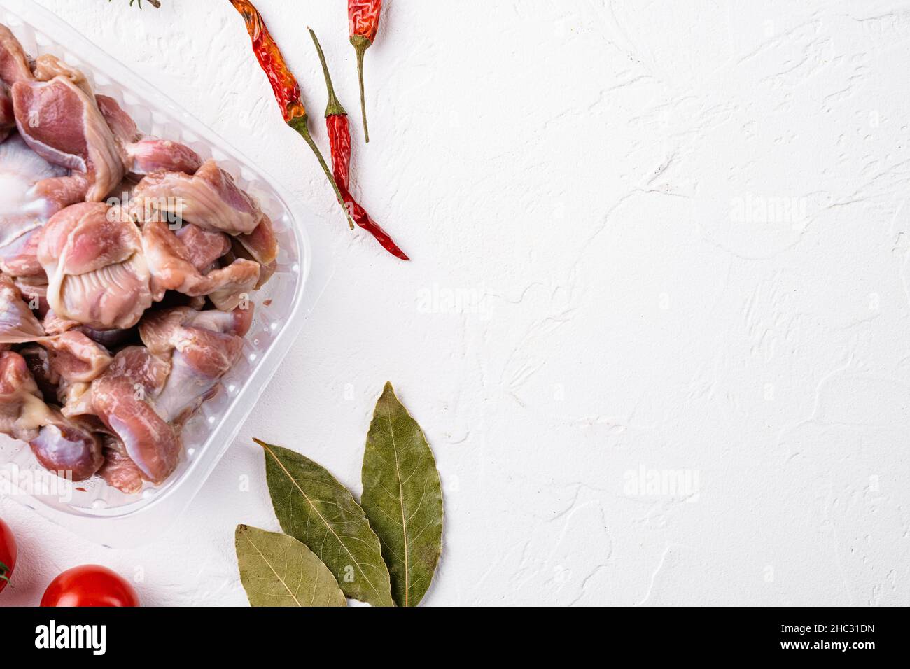 Raw chicken gizzards market plastic pack set, on white stone table ...