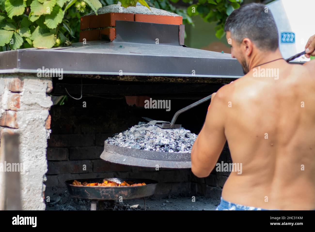 Man preparing and cooking traditional roast of pork beef or veal in ...