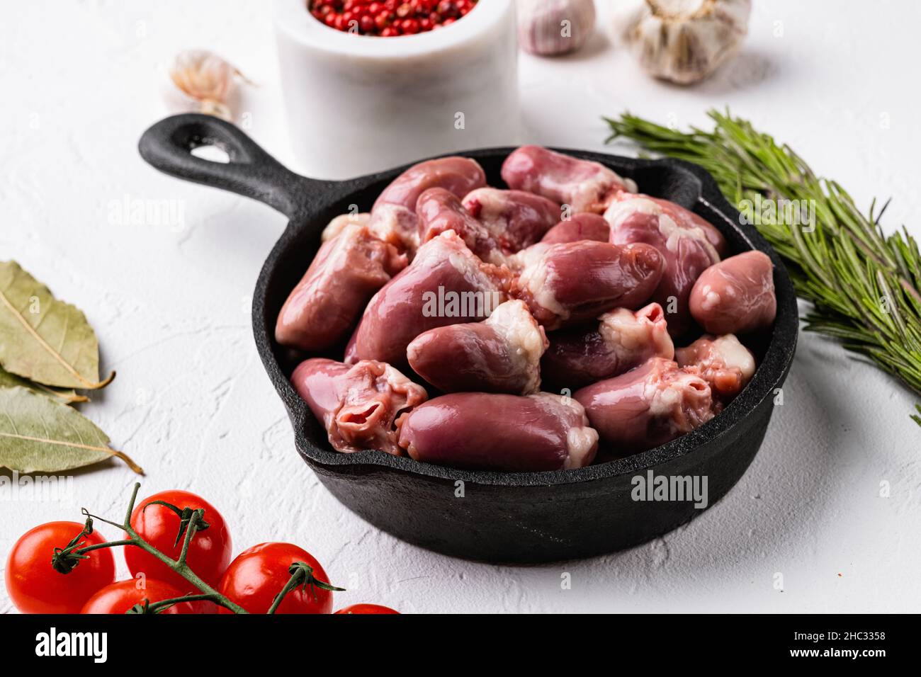 Raw uncooked chicken gizzards, chicken hearts set, on white stone table ...
