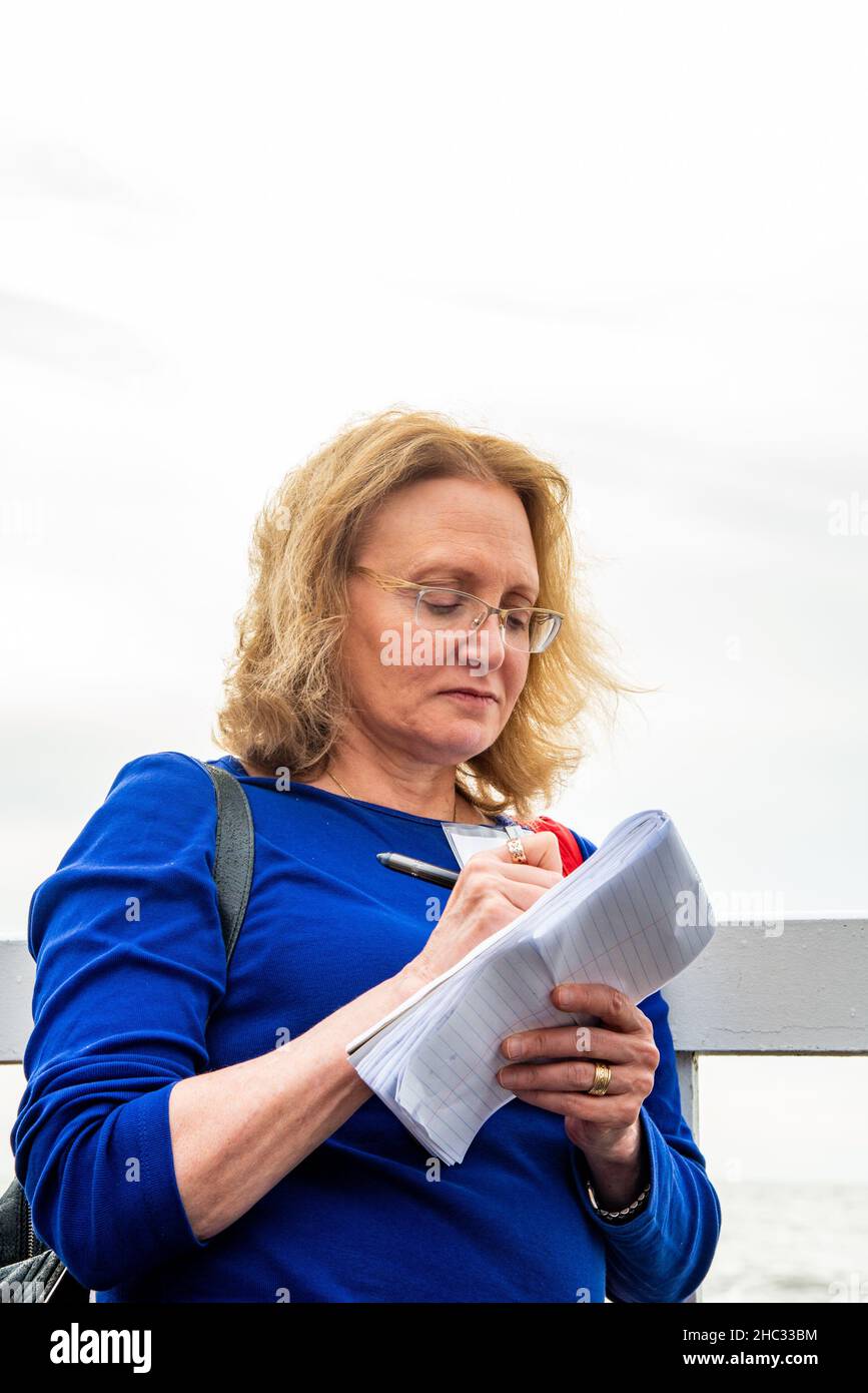 Female journalist taking notes Stock Photo - Alamy
