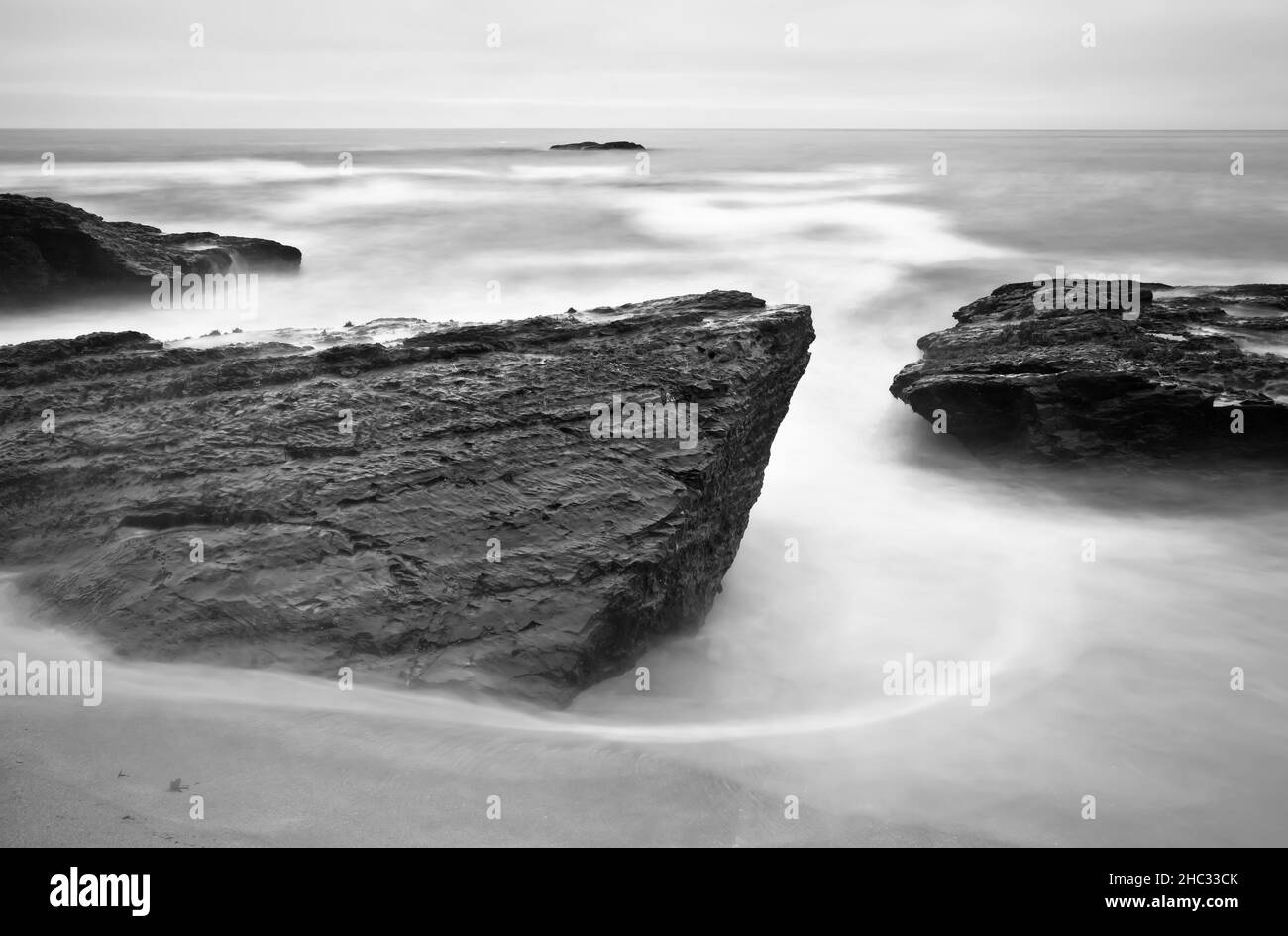 A long exposure photograph captures the movement of ocean waves ...