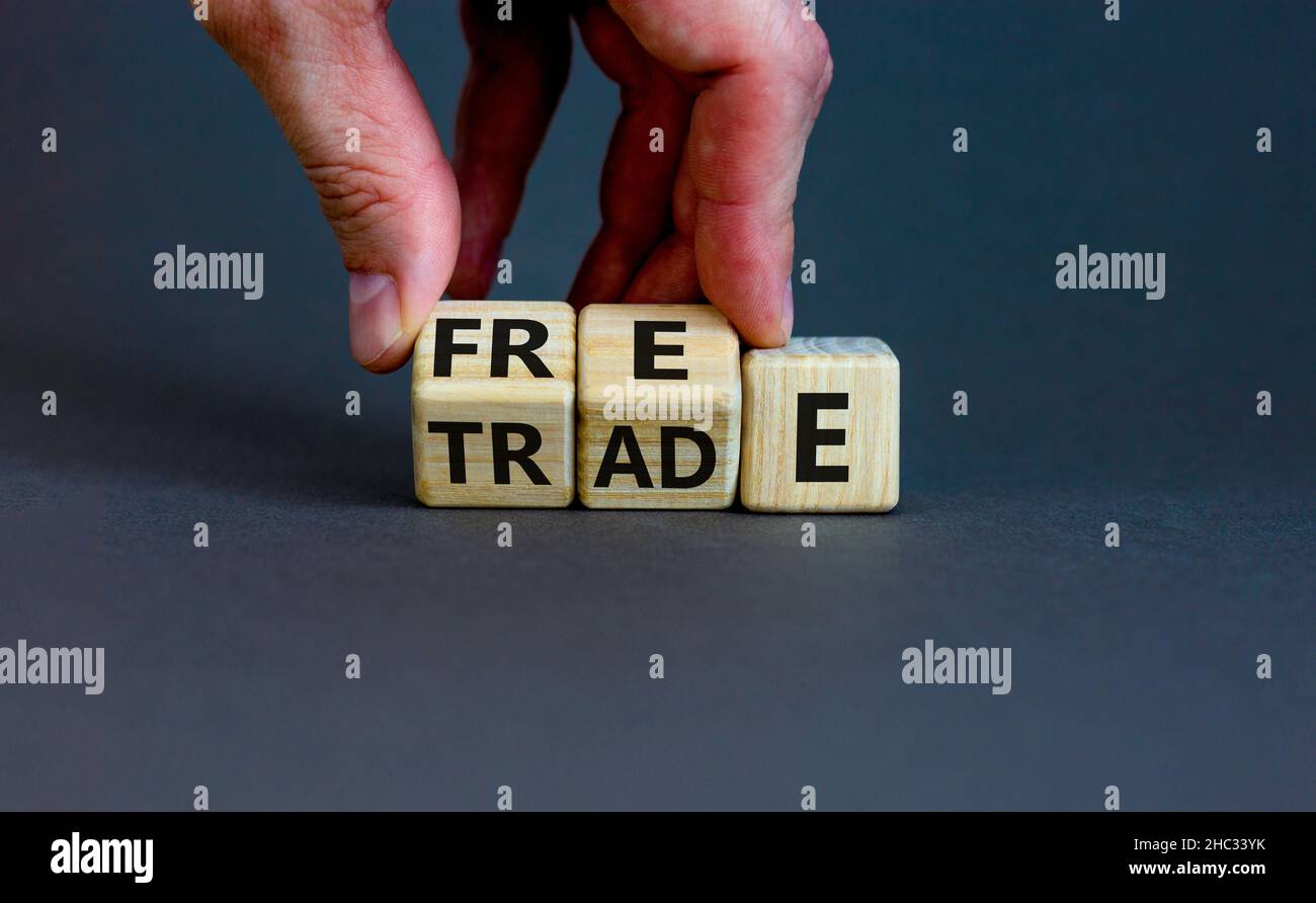 Free trade symbol. Businessman turns wooden cubes and changes the word ...
