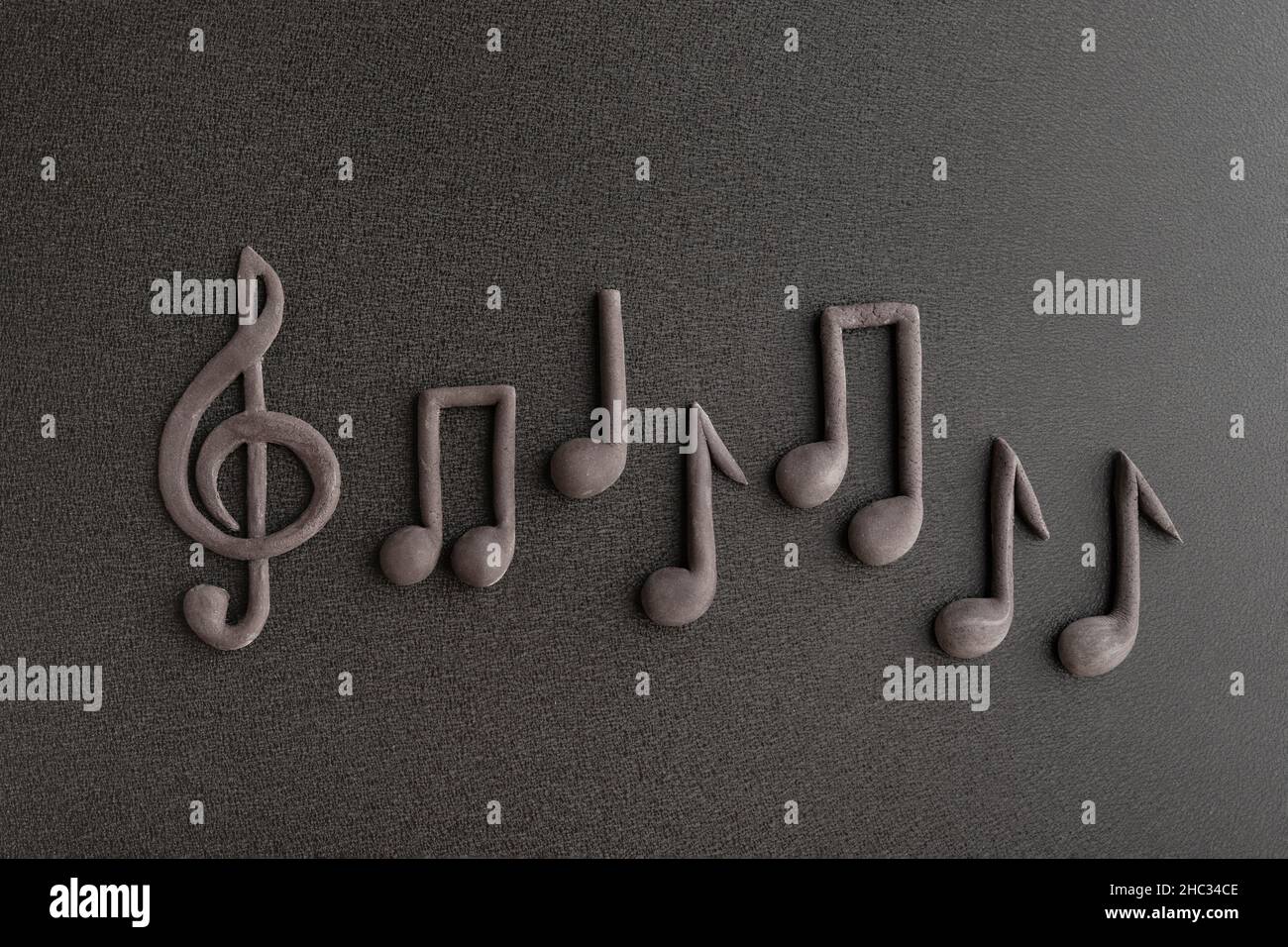 Three-dimensional notes and treble clef on black background. Musical ...