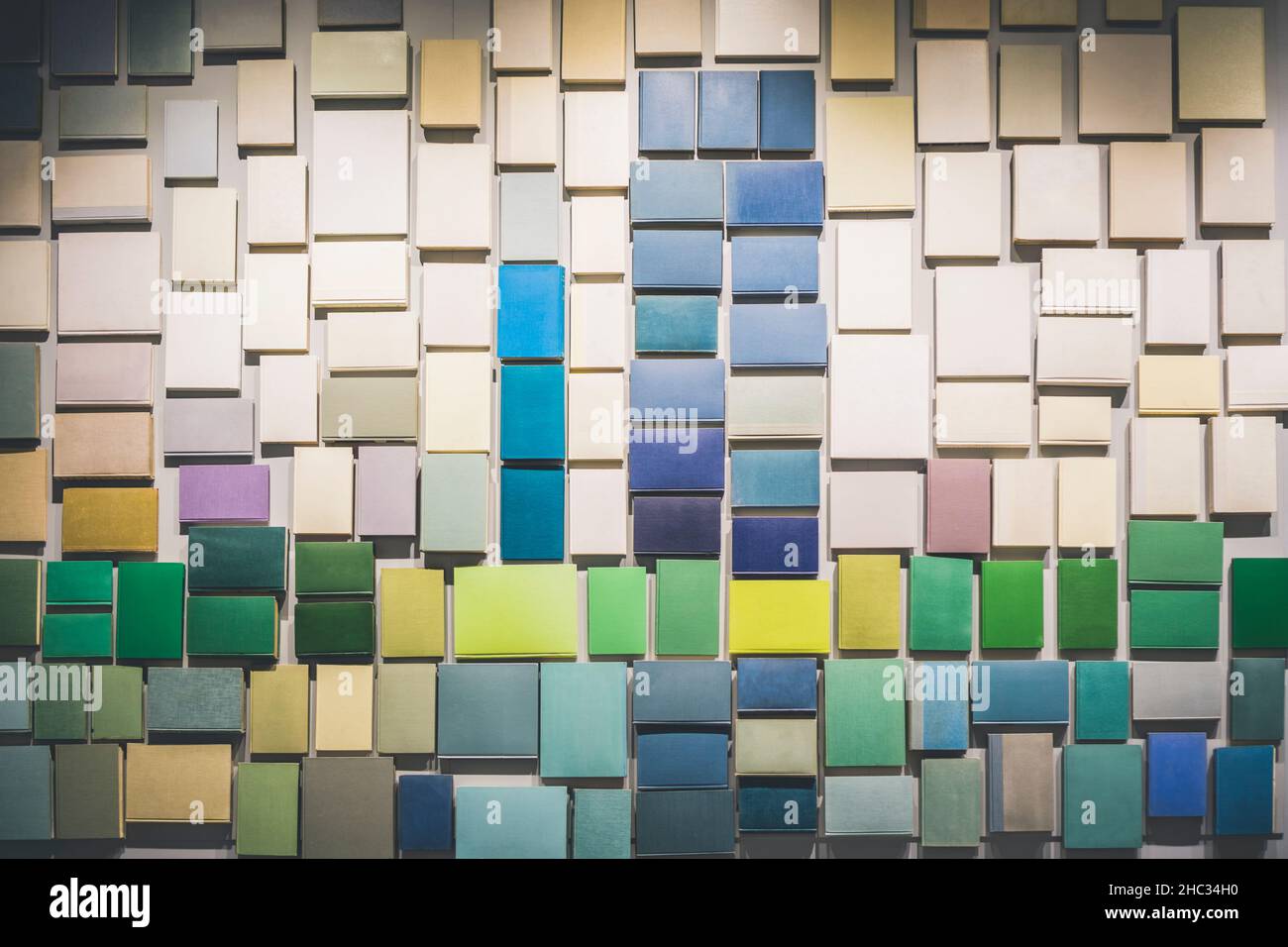 Many books creating feeling of wallpaper attached to a wall. Colorful ...