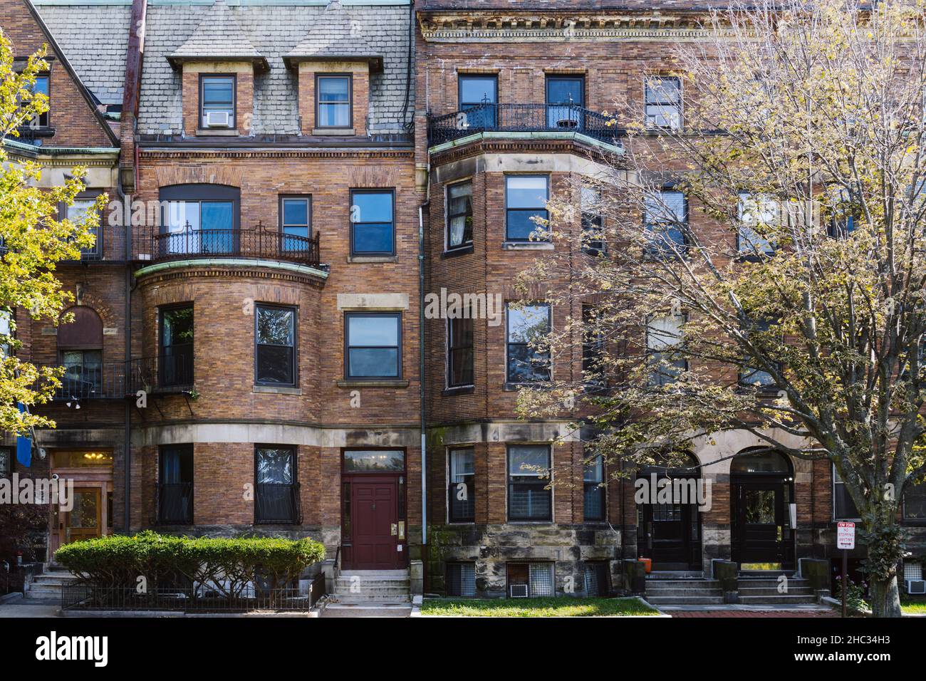 Street view of an old, red brick apartment building in Boston. Row of ...